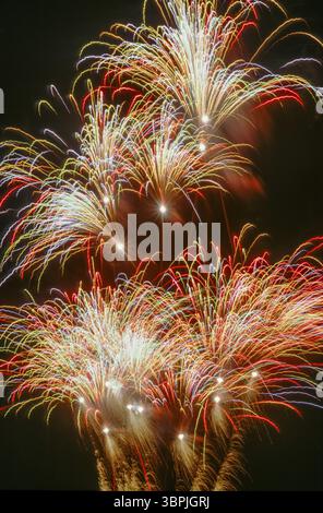 A colorful high-altitude fireworks display in the night sky with ...