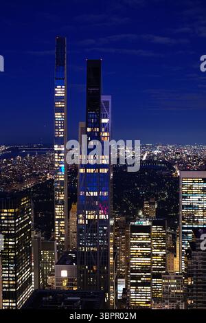 Skyscrapers lit at night in a bustling city with numerous windows ...