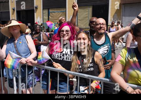 People stand behind a metal barrier, holding Israeli and American flags ...