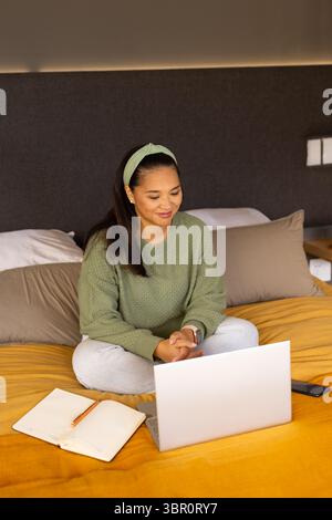 Asian woman studying with laptop and writing in notebook at home Stock ...
