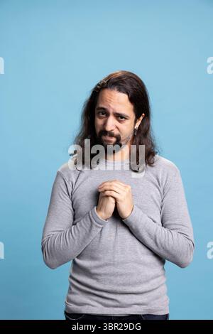 Model with belief praying to God against greenscreen studio backdrop ...