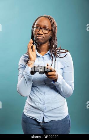 Lady holding gamepad in her hand against red background Stock Photo - Alamy