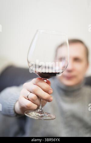 Relaxed serene rich lonely middle aged single man drinking red wine ...