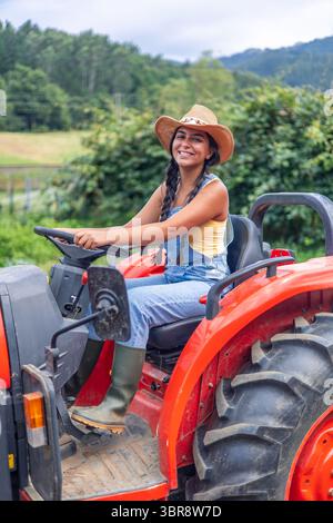 Young woman tractor straw hat rural field plaid shirt overall boot ...