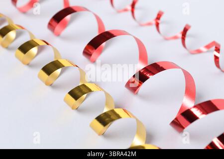 Shiny serpentine streamers on white background. Festive decor Stock ...