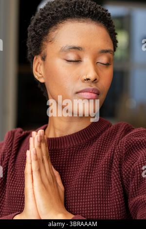 African american woman relaxed with hands on head sitting on sofa at ...