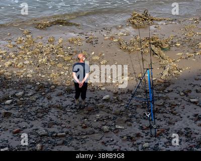 Sea Angler fishes at Seacombe Ferry Terminal during low tide July 2025 ...