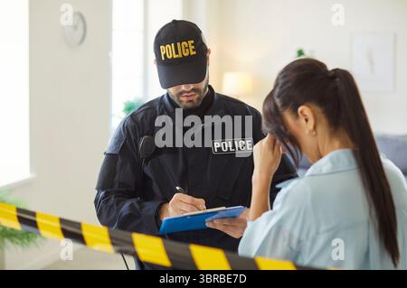 Policeman making victim interview after burglary talking with a young ...