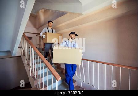 movers carrying two big cardboard box Stock Photo - Alamy