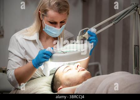 Woman receiving a professional facial treatment, esthetician applying a ...