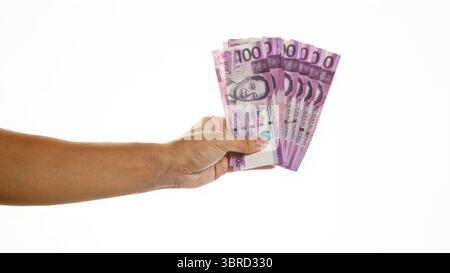 Hand holding philippine pesos over isolated white background ...
