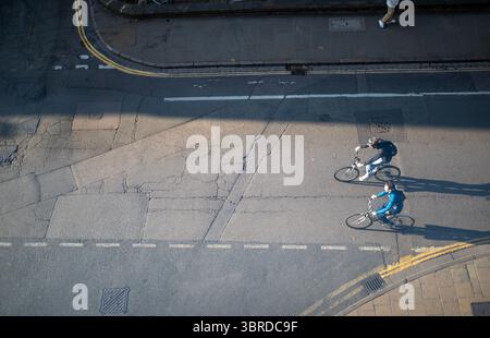 Top aerial view of cyclist and two mans are riding on kick scooters on ...