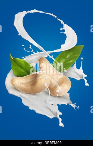 Milk nut splash, cashews and green leaves in air against white ...
