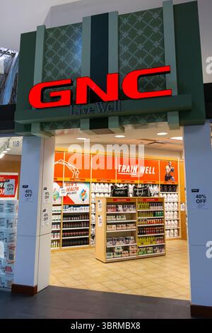 GNC Live Well sign on exterior of commercial building with blue tile ...