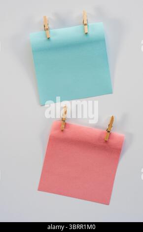 Colorful sticky notes and paper clips arranged on a cork board with ...