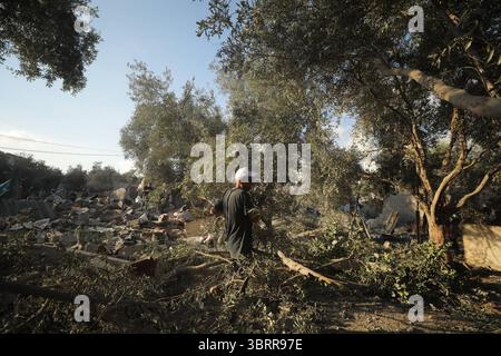 Palestinians assess the damage in the aftermath of an overnight Israeli ...
