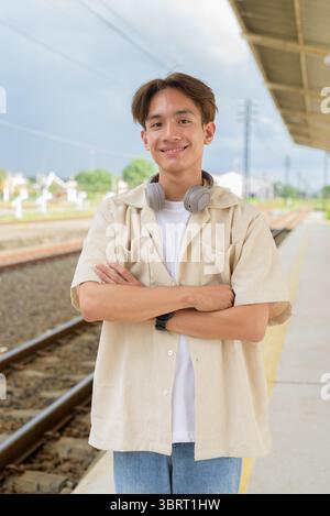 Young Asian non binary tourist traveler in train station Stock Photo ...