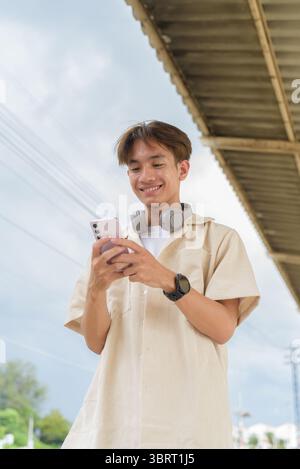 Young Asian non binary tourist traveler in train station Stock Photo ...