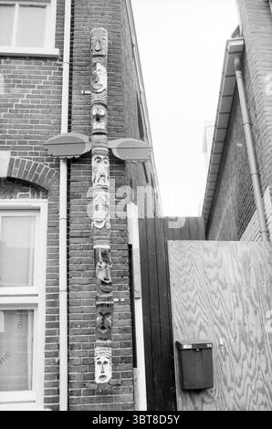 A tall, intricately carved totem features abstract human and animal ...