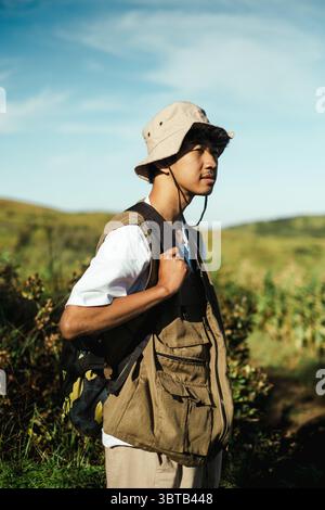 Young man in bucket hat with disposable electronic cigarettes on pink ...
