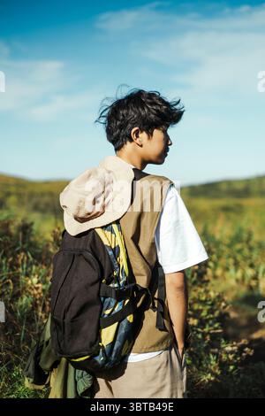 Young man in bucket hat with disposable electronic cigarettes on pink ...