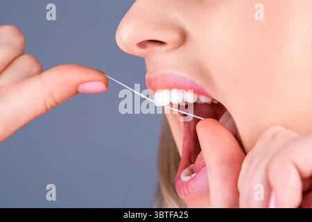Dental flush - woman flossing teeths. Dental floss. Taking care of ...