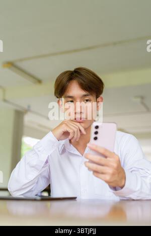 Non binary Asian university student in college campus Stock Photo - Alamy