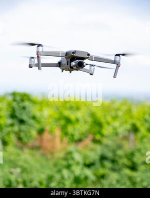 A closeup shot of a drone in the air with swirling wings on a blurry ...