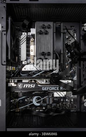 Maykop, Russia - February 18, 2025: Men's fingers install a new M.2 SSD ...