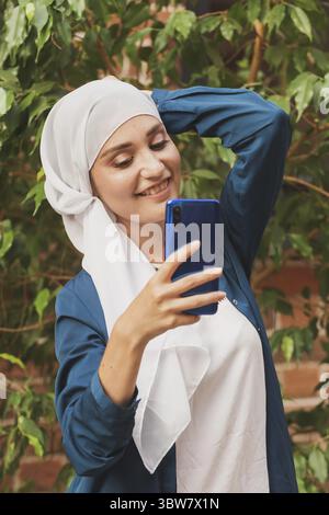 Cropped photo of asian woman using laptop and writing making list ...