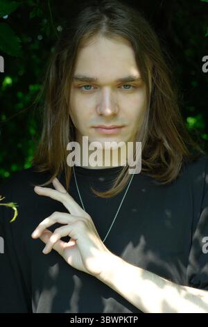 A young man stands confidently in a tailored outfit, showcasing a bold ...