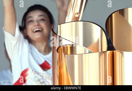 A Tokyo Olympic torch relay participant runs at Higashizawa Rose Park ...