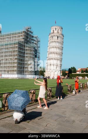 A Young Woman Poses For A Photo At The Leaning Tower of Pisa, The Field ...