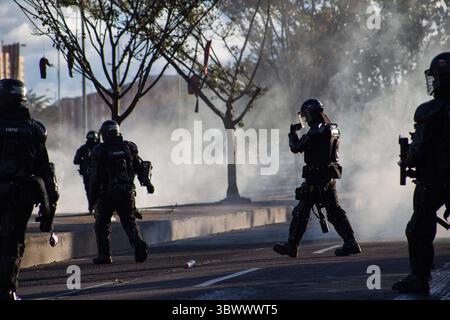 Colombia's riot police stay behind a tear gas cloud during a new day of ...