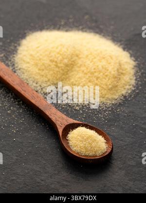 Coarse wheat semolina flour in a bowl and wooden spoon - Triticum Stock ...