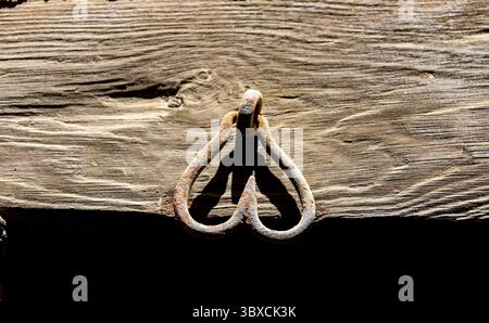 Inverted heart-shaped shackle on wooden beam Stock Photo - Alamy