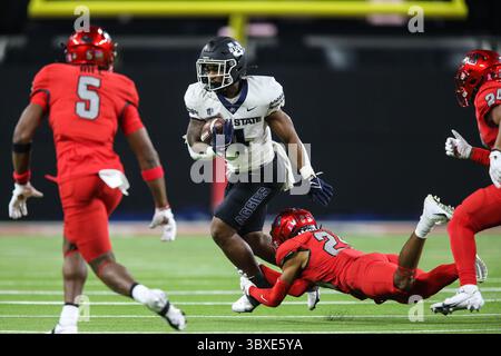 Utah State running back Calvin Tyler Jr. (4) gets past Hawaii defensive ...