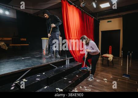Actors cleaning the stage after a performance in a theatre setting ...