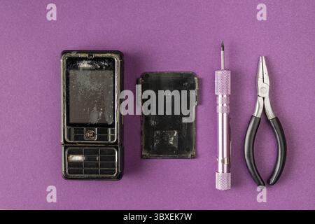 Old broken smartphone and repair tool. The concept of computer ...