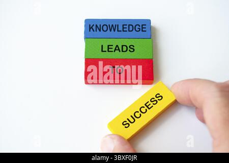 Knowledge leads to success text on multicolored wooden blocks on white ...