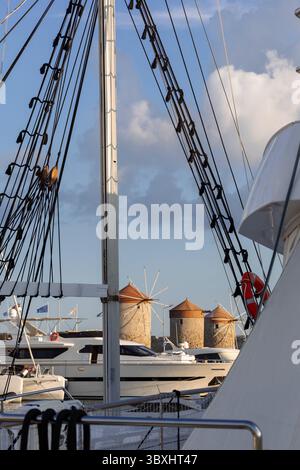 Colorful panoramic view of windmills with yachts in Mandraki harbor at ...