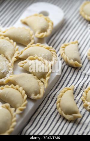 Board with raw dumplings and ingredients on grey background Stock Photo ...