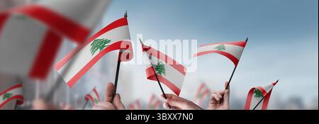 Lebanon flags in their hands on a blurred urban background Stock Photo ...