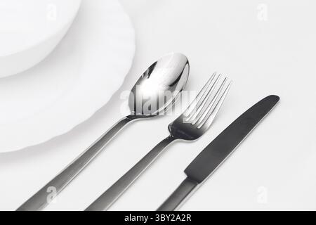 Plates, spoon and fork on white background Stock Photo - Alamy