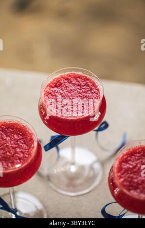 Glasses of cocktails on table on blue sea background Stock Photo - Alamy