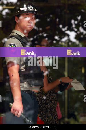 A security guard stands at the entrance of the Bank of Japan ...