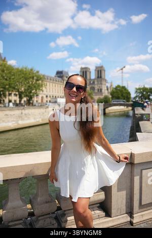 Bright in Paris. happy elegant woman in red trench coat on embankment ...