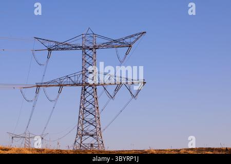A low angle shot of a silhouette of a utility pole against a cloudy ...
