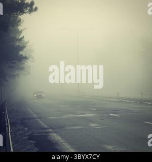 Bad weather driving - foggy hazy country road. Motorway - road traffic ...