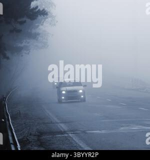 Bad weather driving - foggy hazy country road. Motorway - road traffic ...